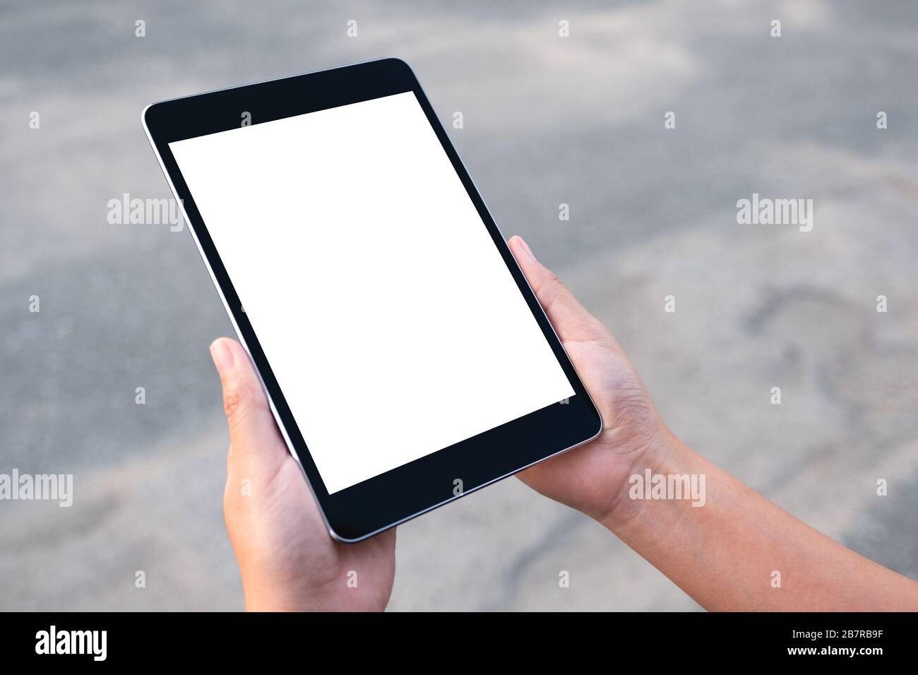 Mockup image of hands holding black tablet pc with blank white screen ...