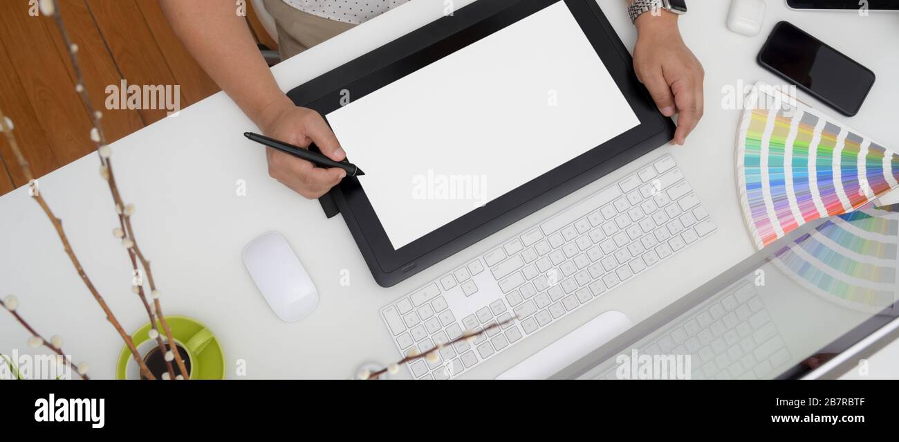 Overhead Shot Of Designer Working On Mock Up Tablet Computer Device Smartphone And Colour