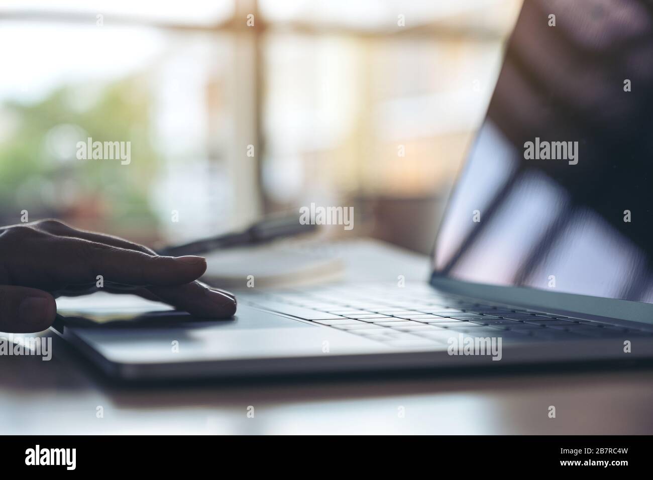 Closeup image of hands using and touching on laptop touchpad on wooden ...