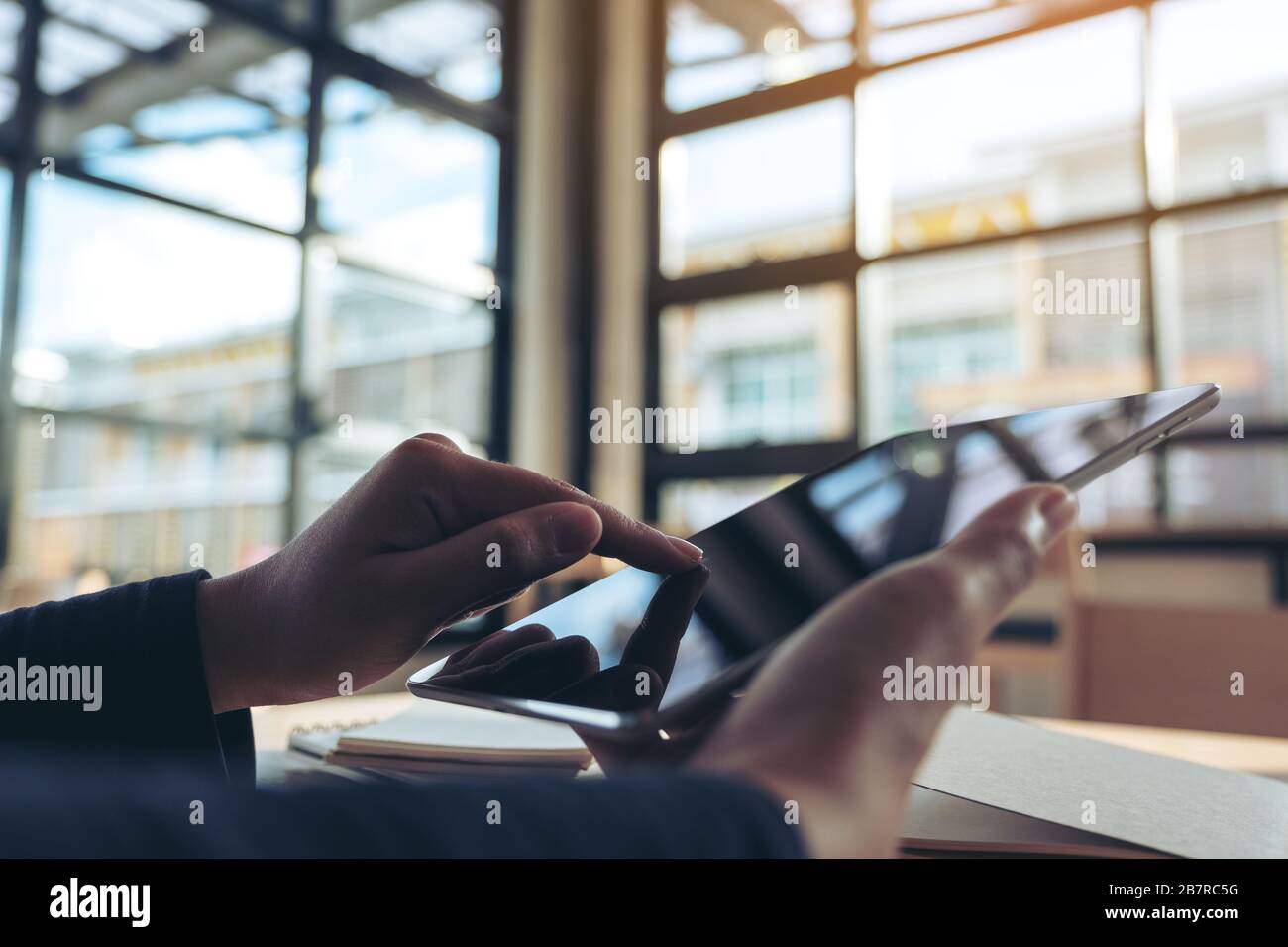 Closeup image of hands holding and pointing at a black tablet pc screen ...
