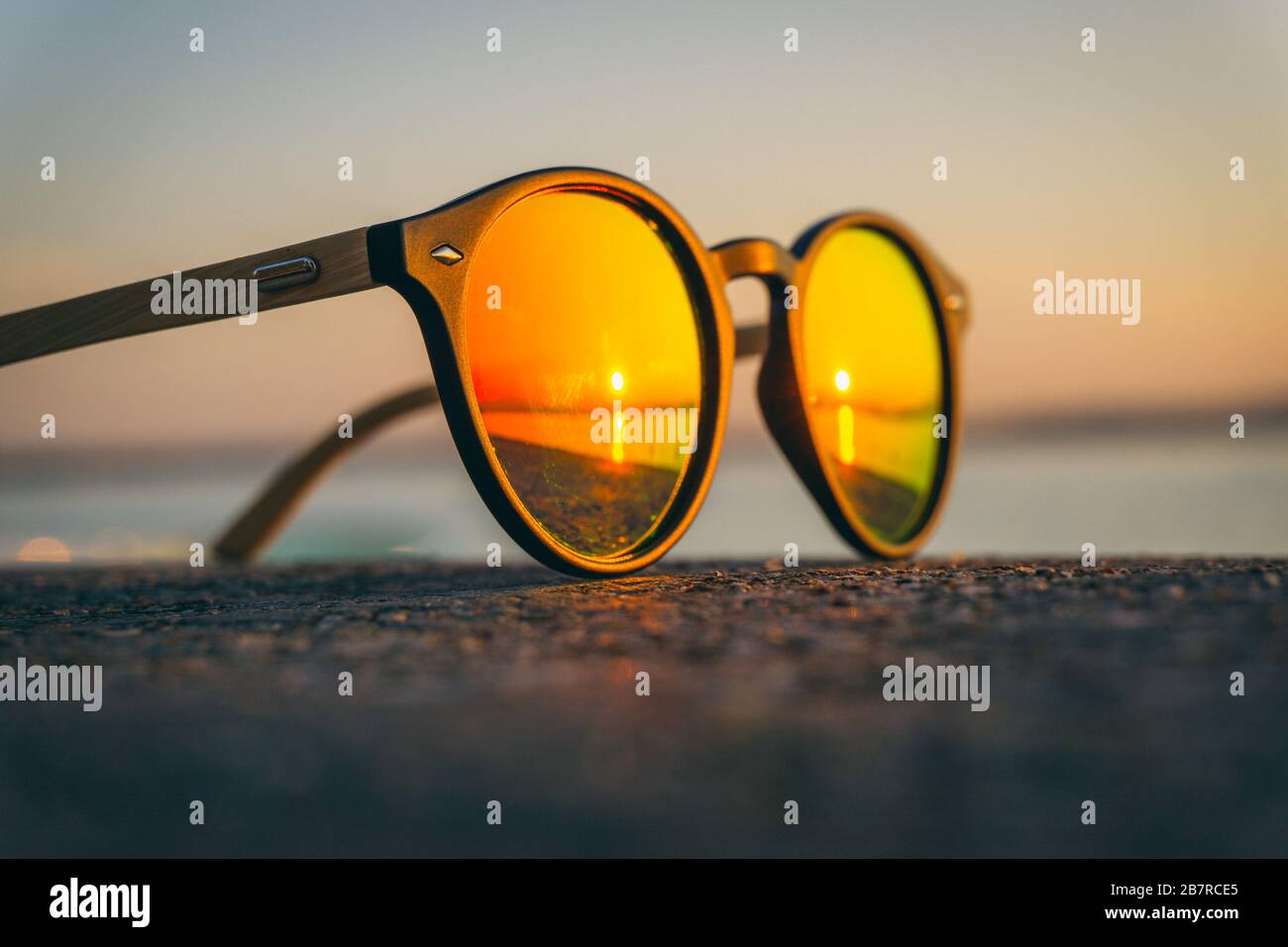 Pair of sunglasses on the beach with the reflection of the sunset Stock ...