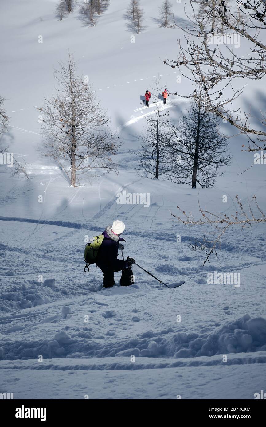 Vertical shot of a mountain covered in snow, people hiking in Col de la ...