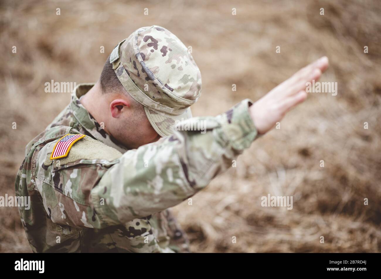 Selective focus shot of an American soldier with his hand raised above ...