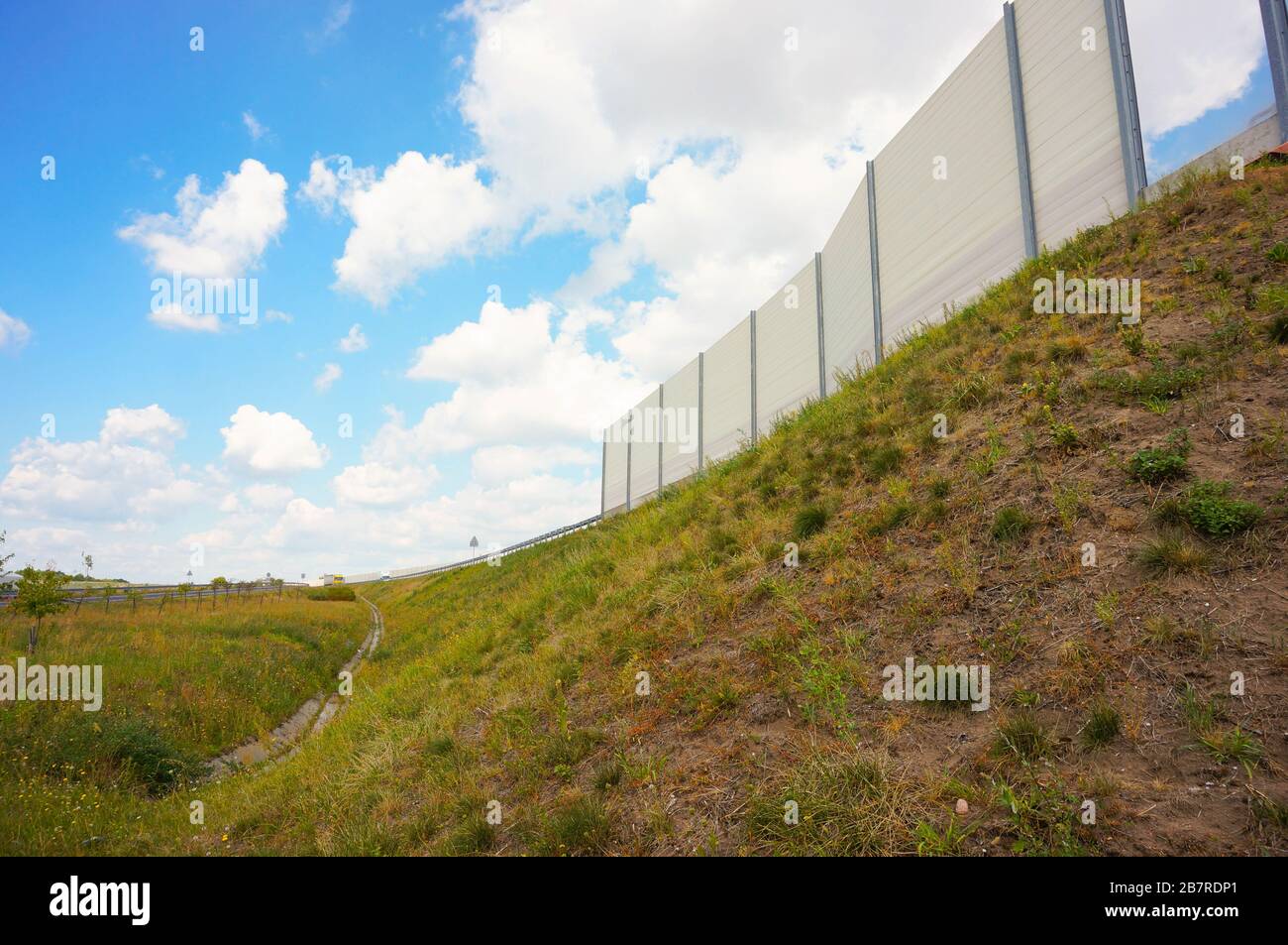 Wall constructed on a green field under a sky full of clouds Stock ...