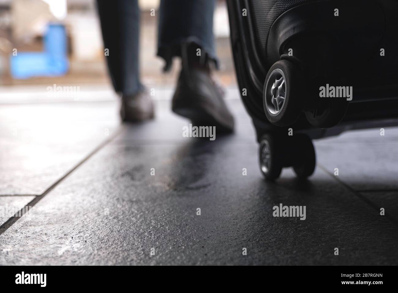 Closeup image of a woman's feet while traveling and dragging a black ...