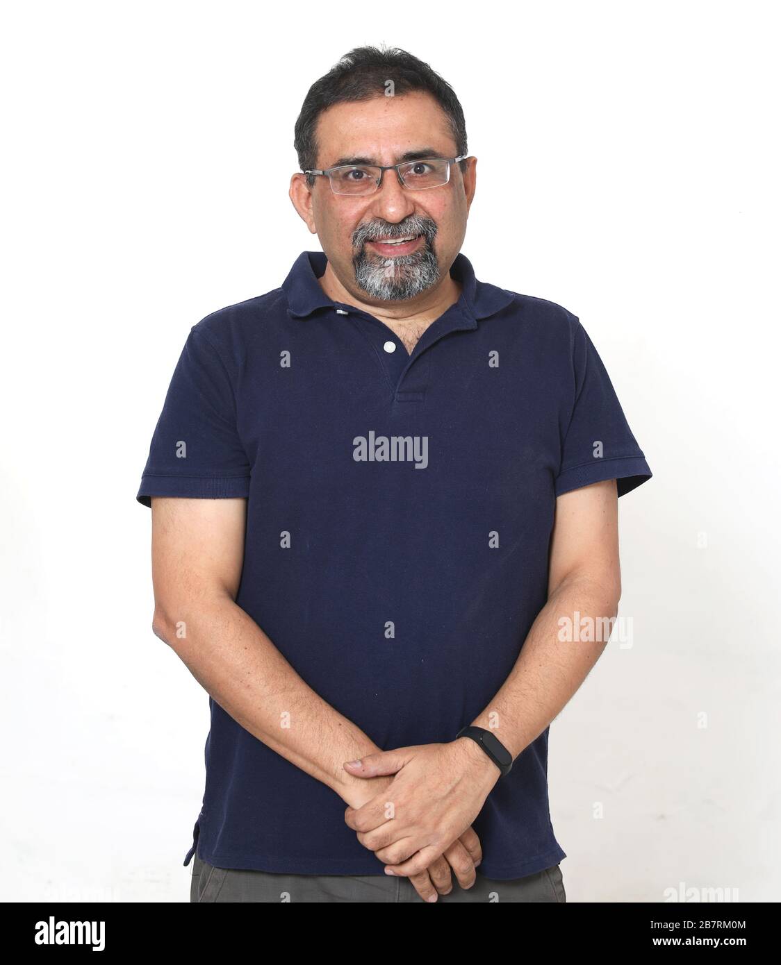 A smiling Indian man with a goatee in a studio against a white ...