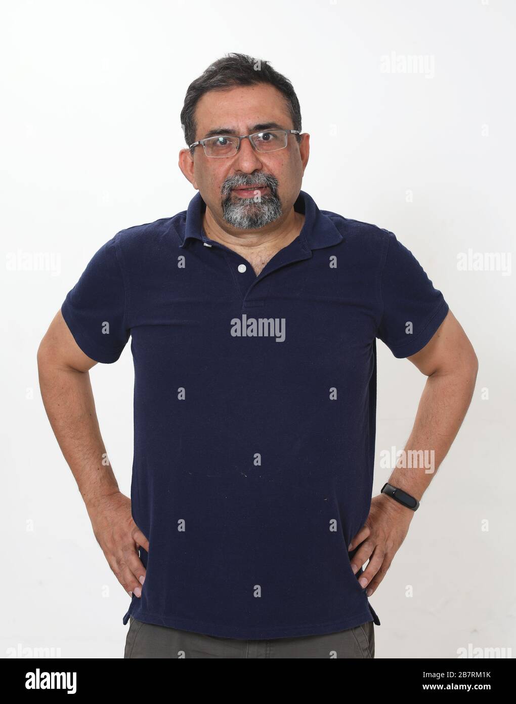 A smiling Indian man with a goatee in a studio against a white ...
