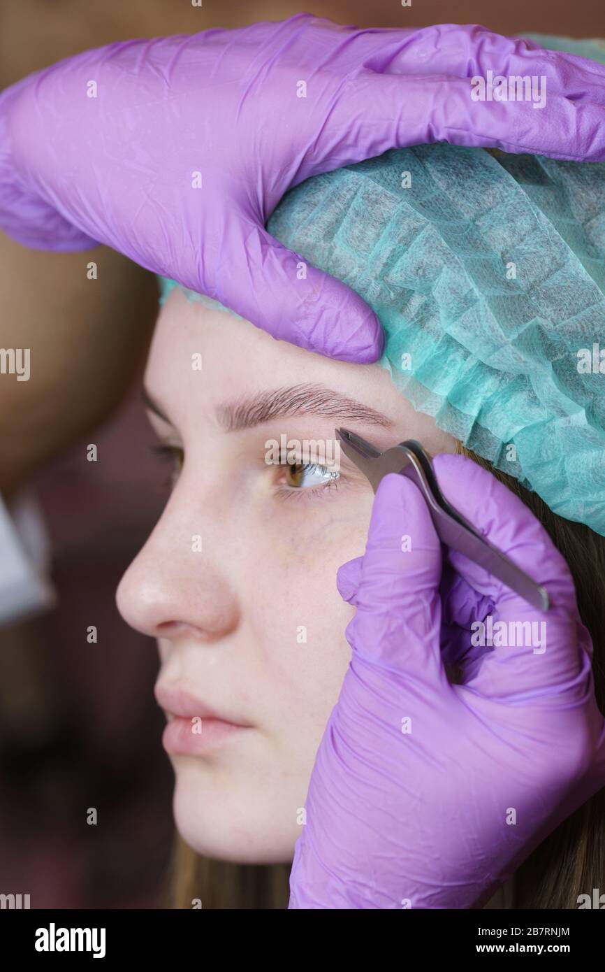 Eyebrow correction with tweezers. Final stage of creating perfect shape ...