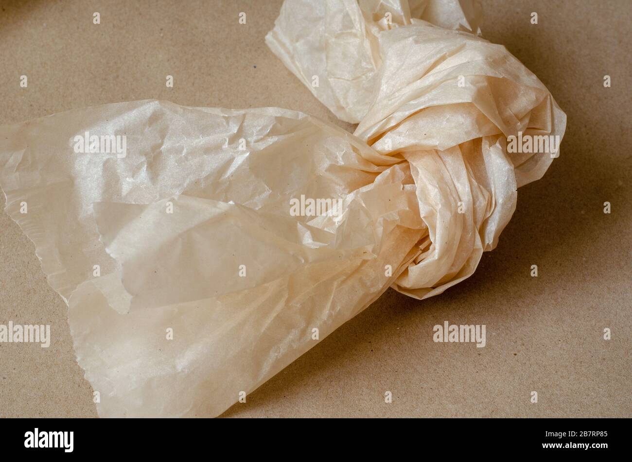 Wrapping paper tied in a knot. Crumpled piece of paper with a torn edge ...