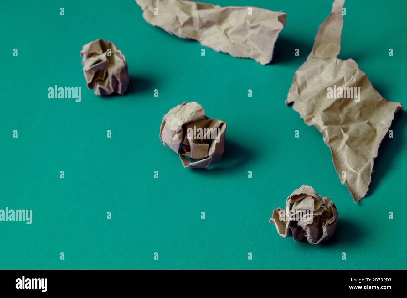 Crumpled and torn pieces of paper on a light turquoise background ...