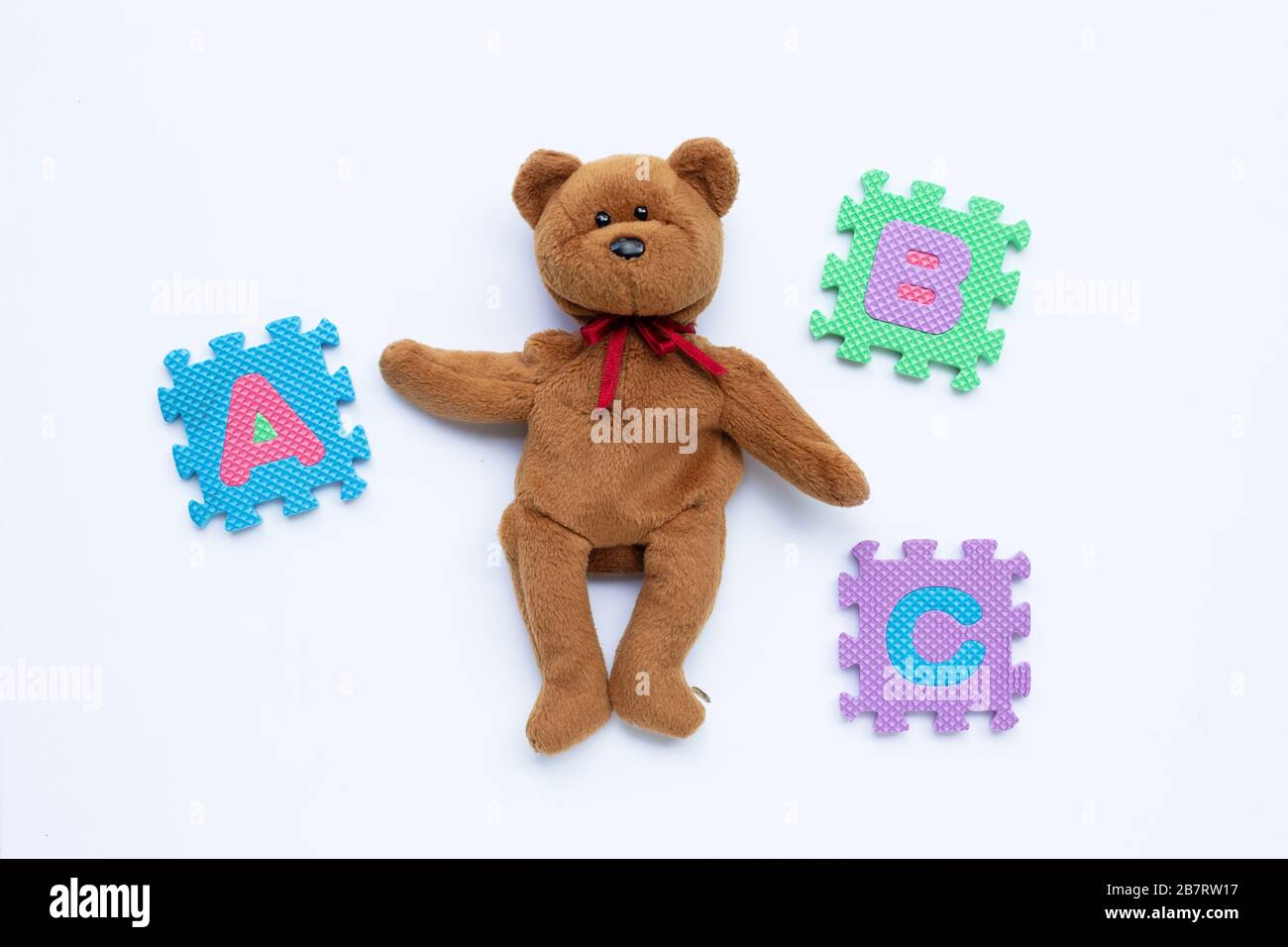 Brown bear toy with english alphabet puzzle on white background ...