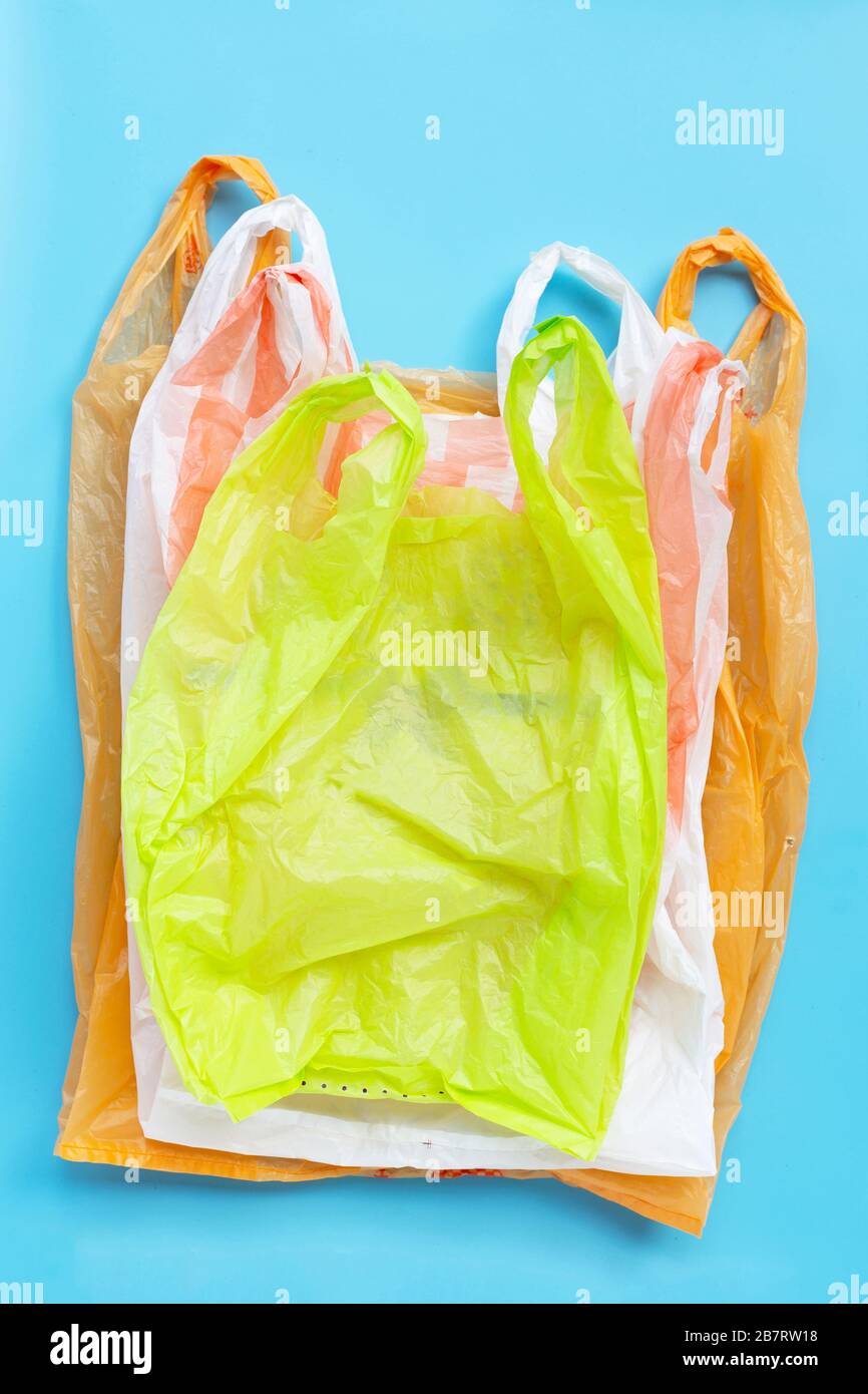 Colorful plastic bags on blue background. Environment pollution concept ...