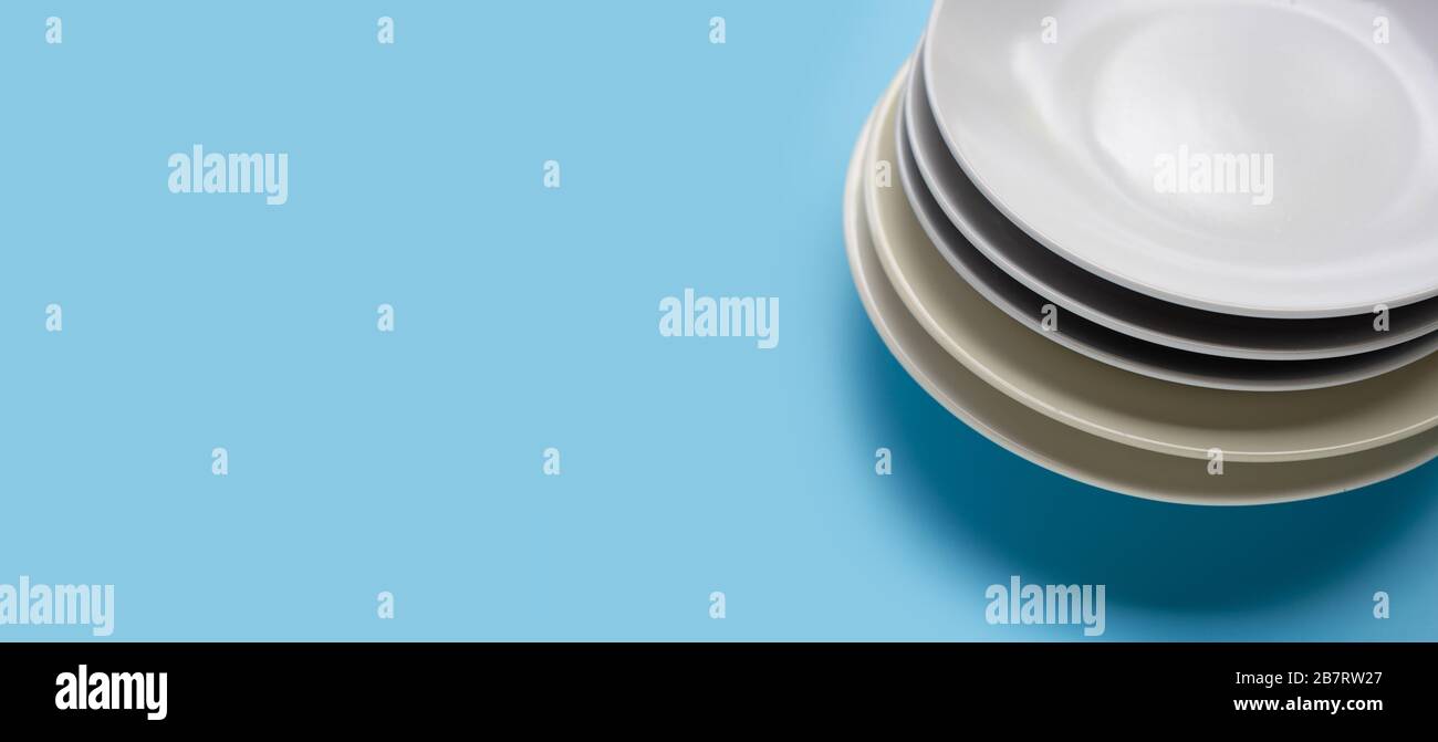 Stack of dishes on blue background. Copy space Stock Photo - Alamy