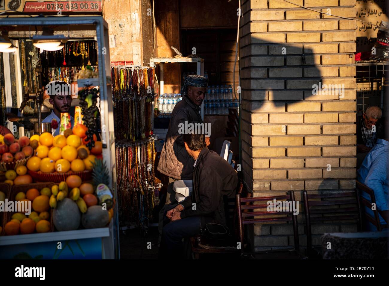 Iraq, Iraqi Kurdistan, Arbil, Erbil. A man is sitting at sunset on a ...