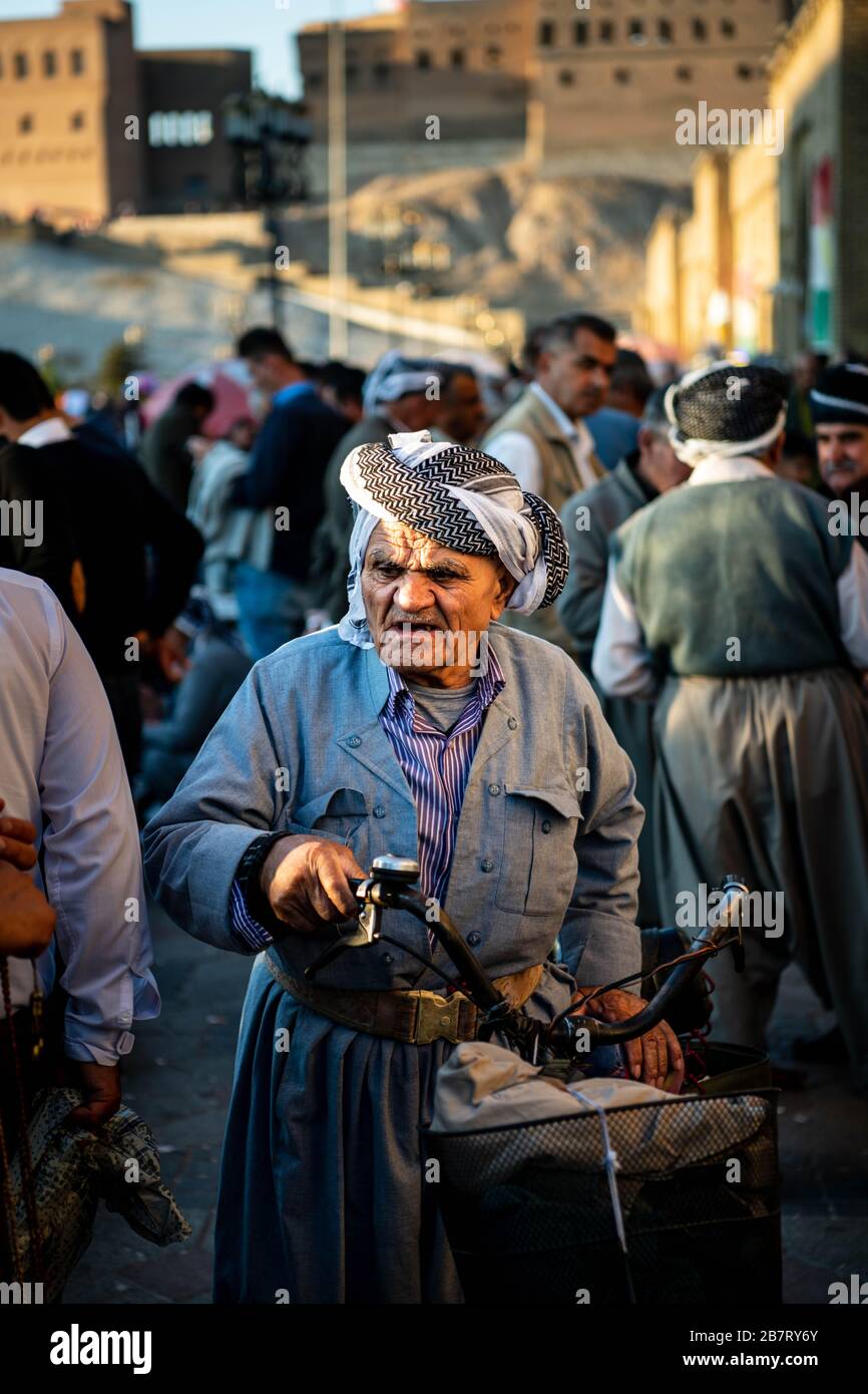 Iraq, Iraqi Kurdistan, Arbil, Erbil. A man is pushing a bicycle on a ...