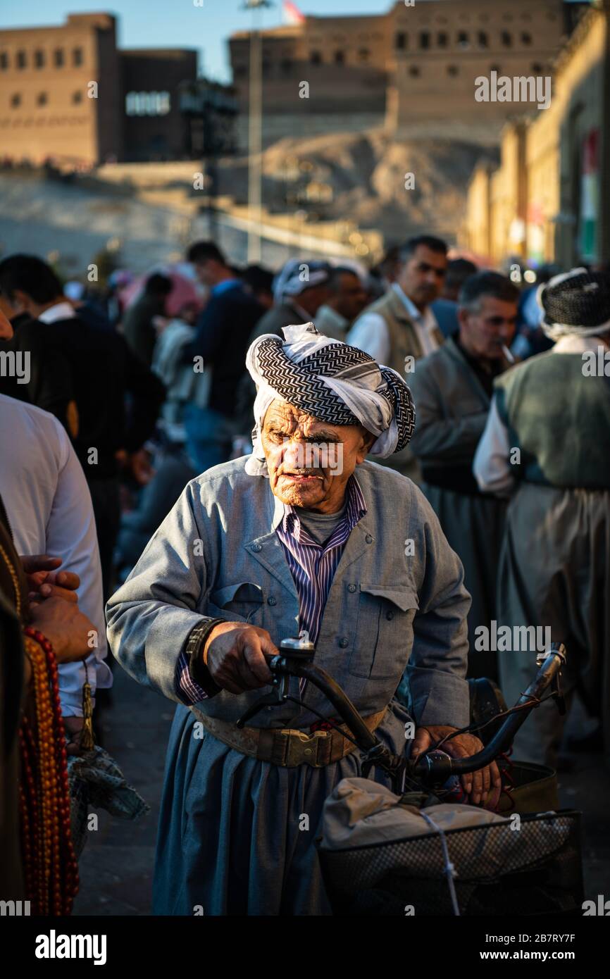 Iraq, Iraqi Kurdistan, Arbil, Erbil. A man is pushing a bicycle on a ...