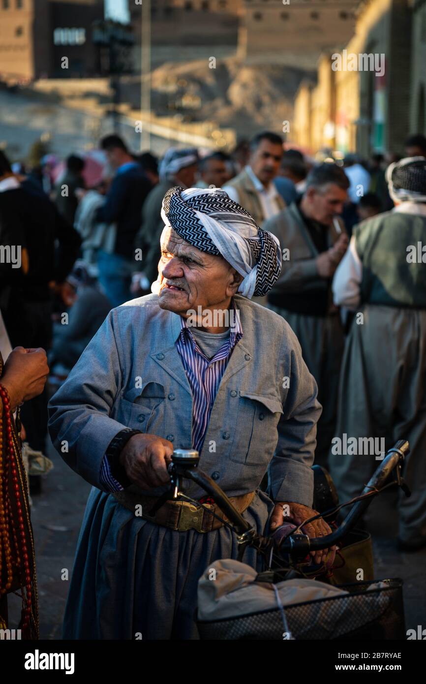 Iraq, Iraqi Kurdistan, Arbil, Erbil. A man is pushing a bicycle on a ...