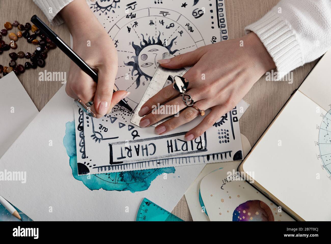 Top view of astrologer drawing birth chart with watercolor paintings of ...