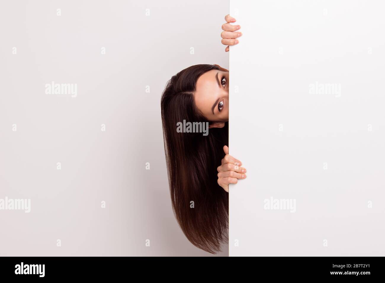 Woman peering around wall hi-res stock photography and images - Alamy
