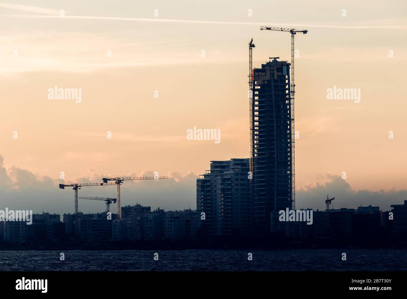 Silhouettes of unfinished high-rise buildings after sunset, Limassol ...