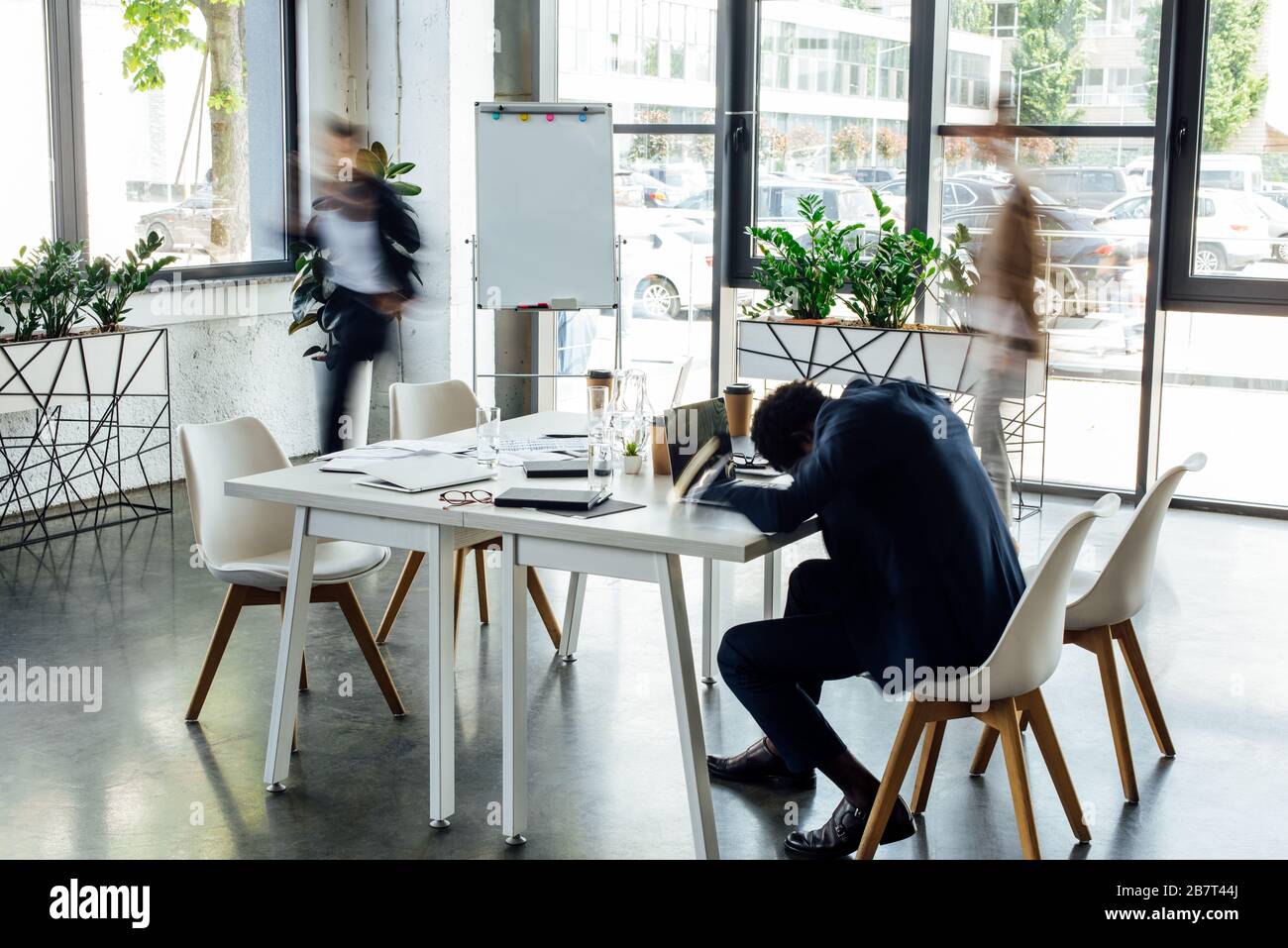 back view of african american businessman sleeping on table in office ...