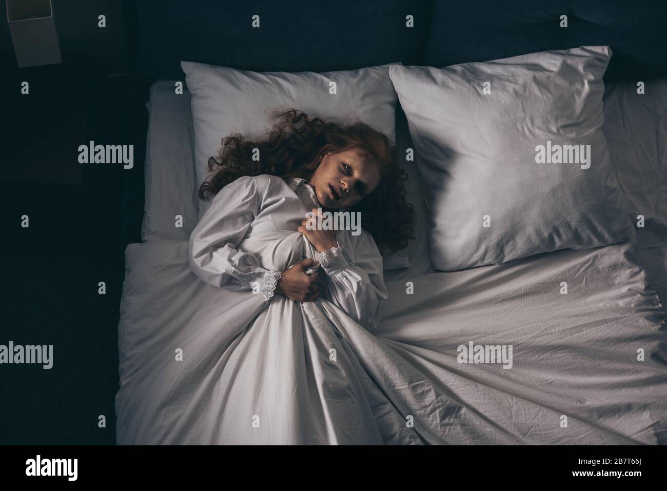 top view of paranormal gothic girl in nightgown lying in bed Stock ...