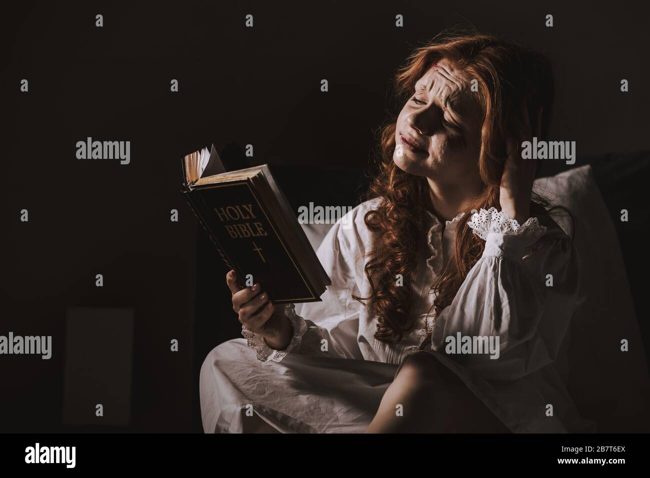 creepy demoniacal crying woman reading holy bible on bed Stock Photo ...