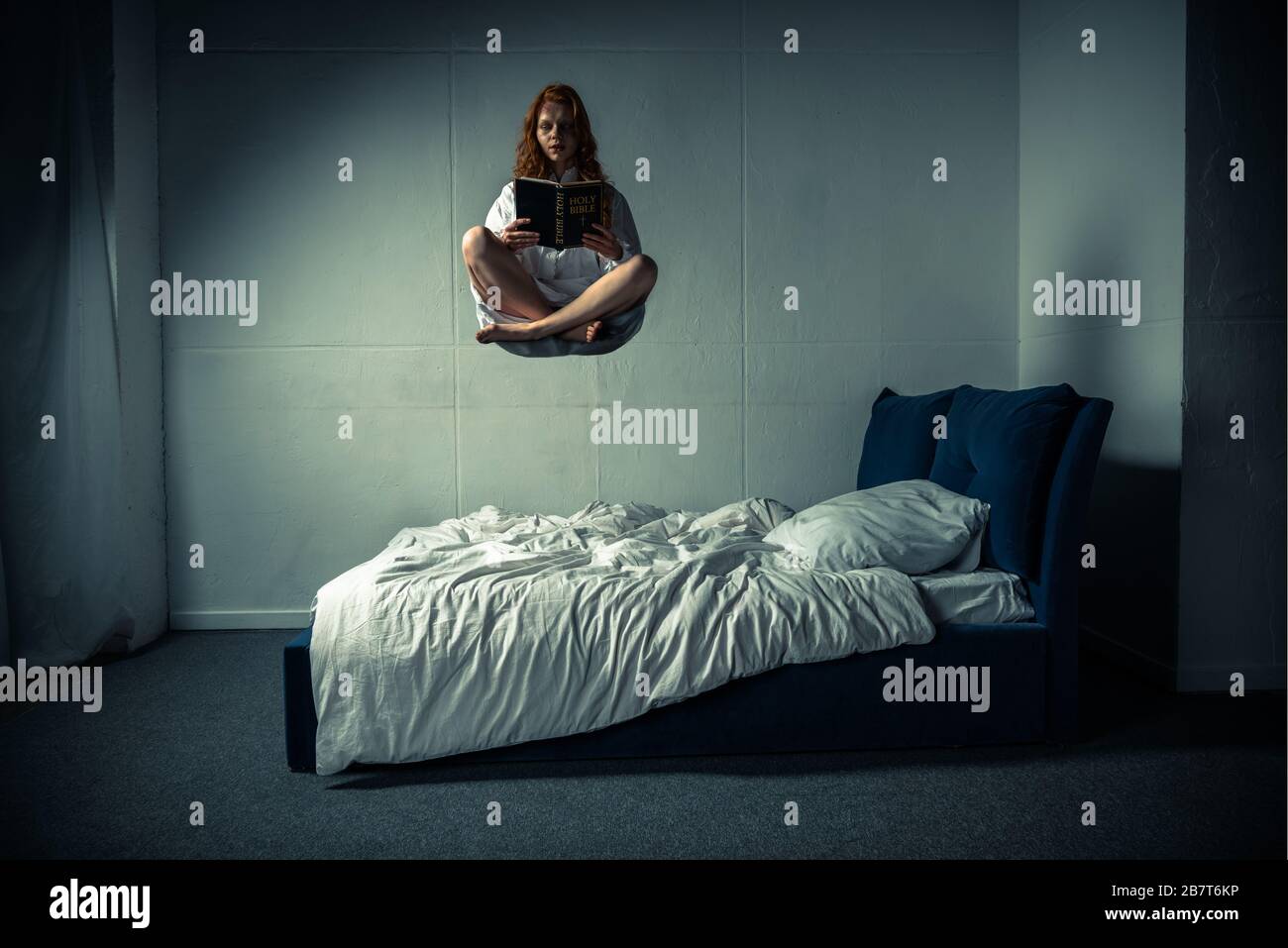 demonic woman in nightgown levitating over bed while reading bible ...