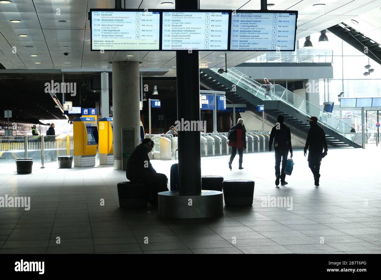 A man sits under train information at The Hague Central station on ...
