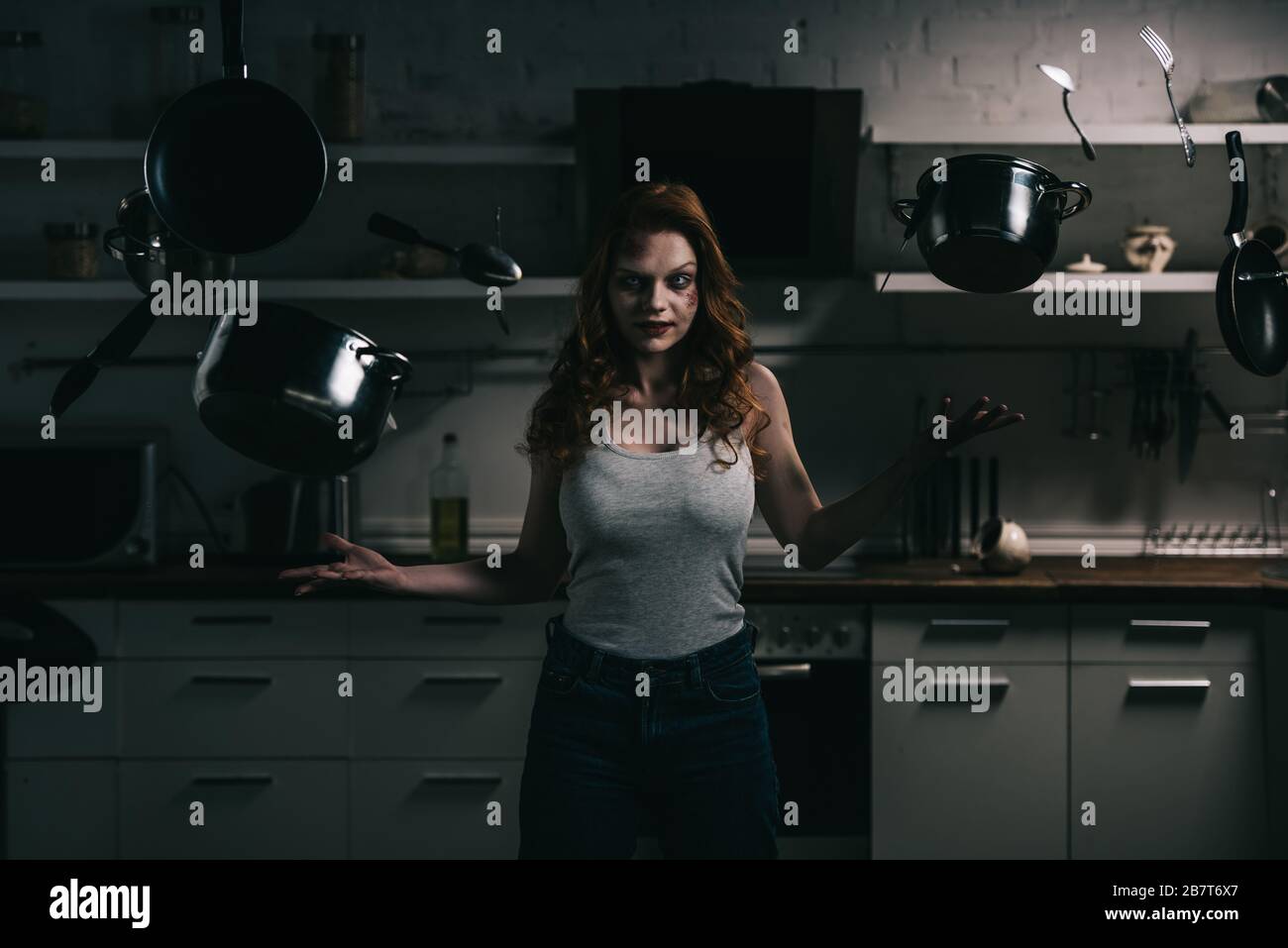 creepy female demon gesturing with levitating kitchenware in kitchen ...