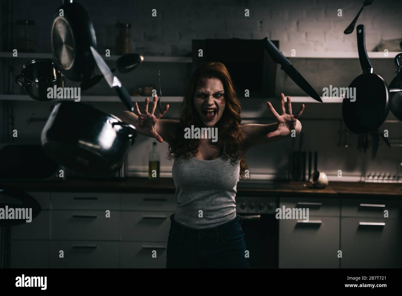 creepy demoniacal yelling girl with levitating kitchenware in kitchen ...