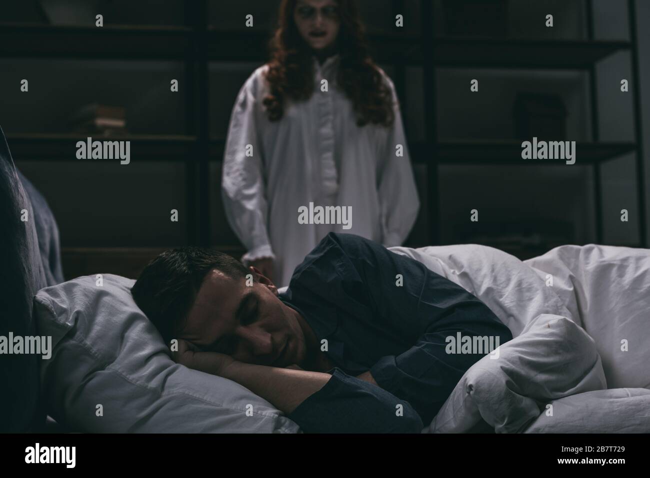 obsessed woman standing near bed with sleeping man Stock Photo - Alamy