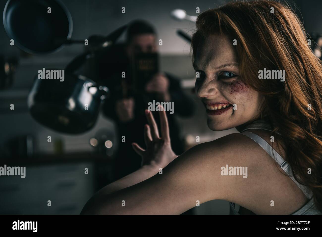 selective focus of exorcist and smiling demon with levitating cookware ...