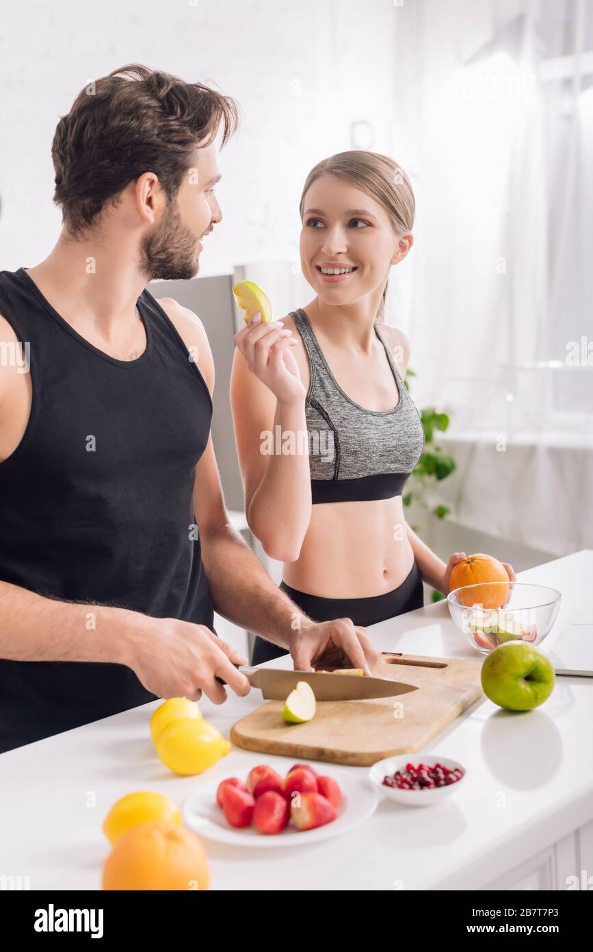 happy man cutting apple near woman in sportswear Stock Photo - Alamy