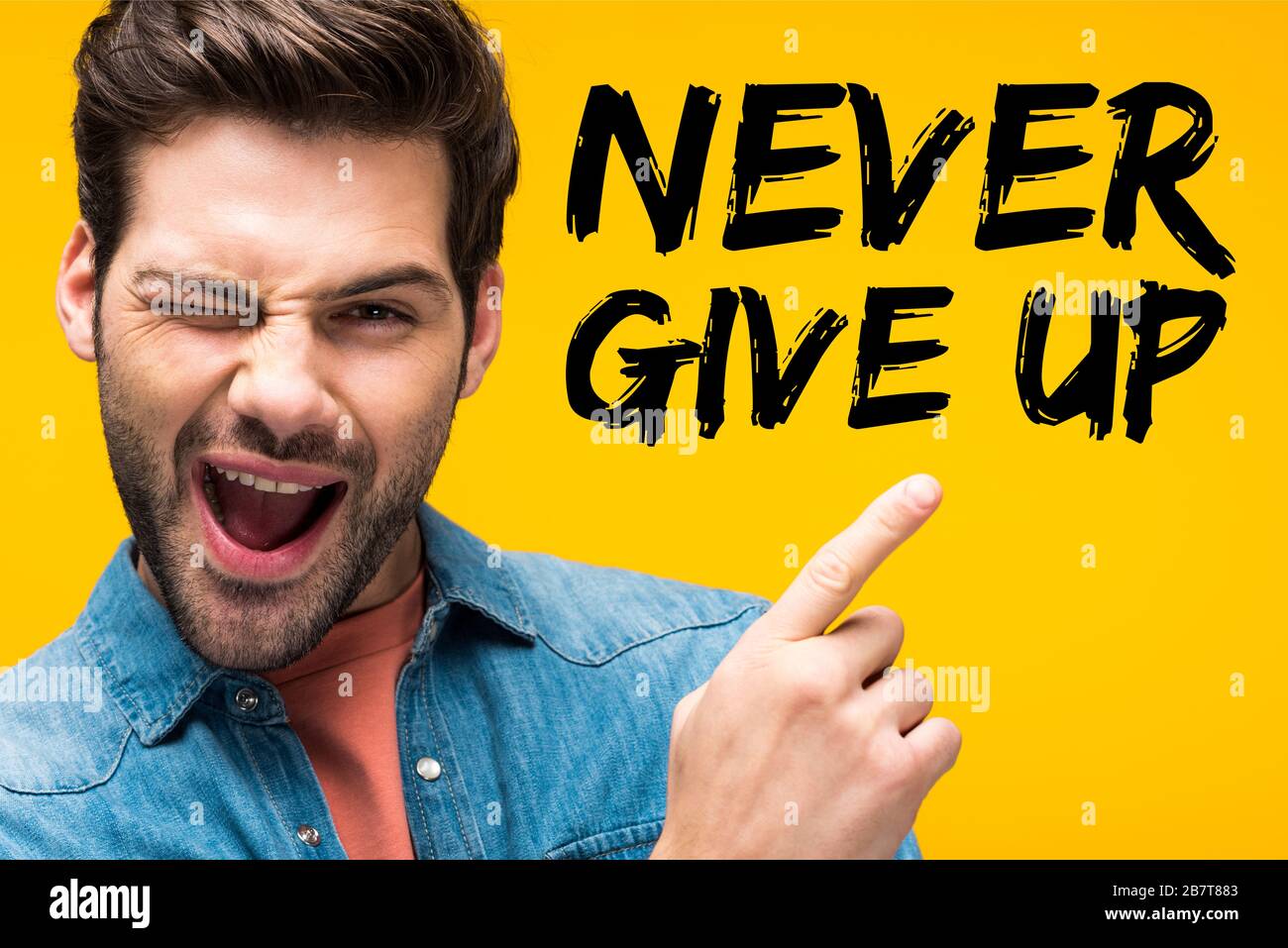 handsome man pointing with finger at never give up lettering and ...