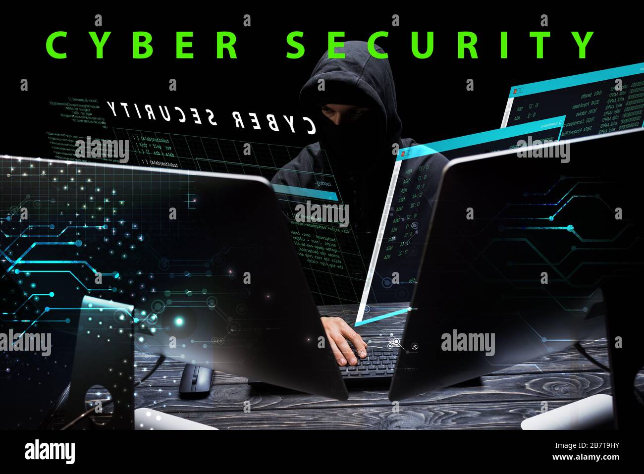 hacker in hood sitting near computer monitors near cyber security ...