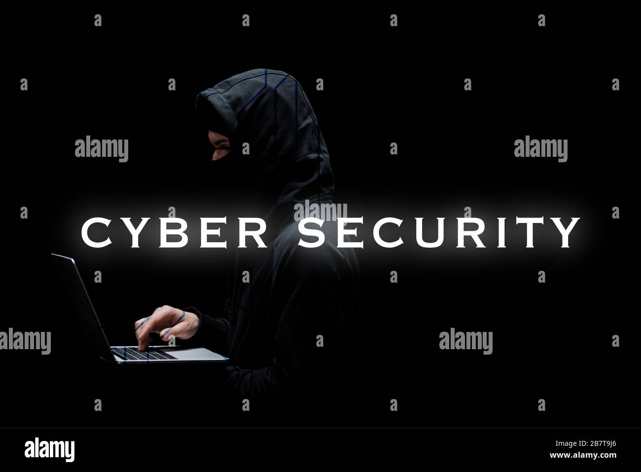 anonymous hacker in hood and mask using laptop near cyber security ...