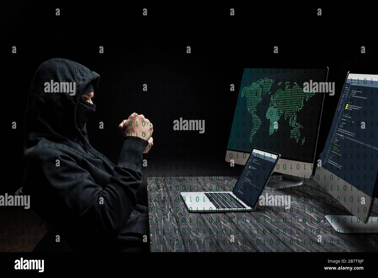 hacker with clenched fists looking at laptop with near computer ...