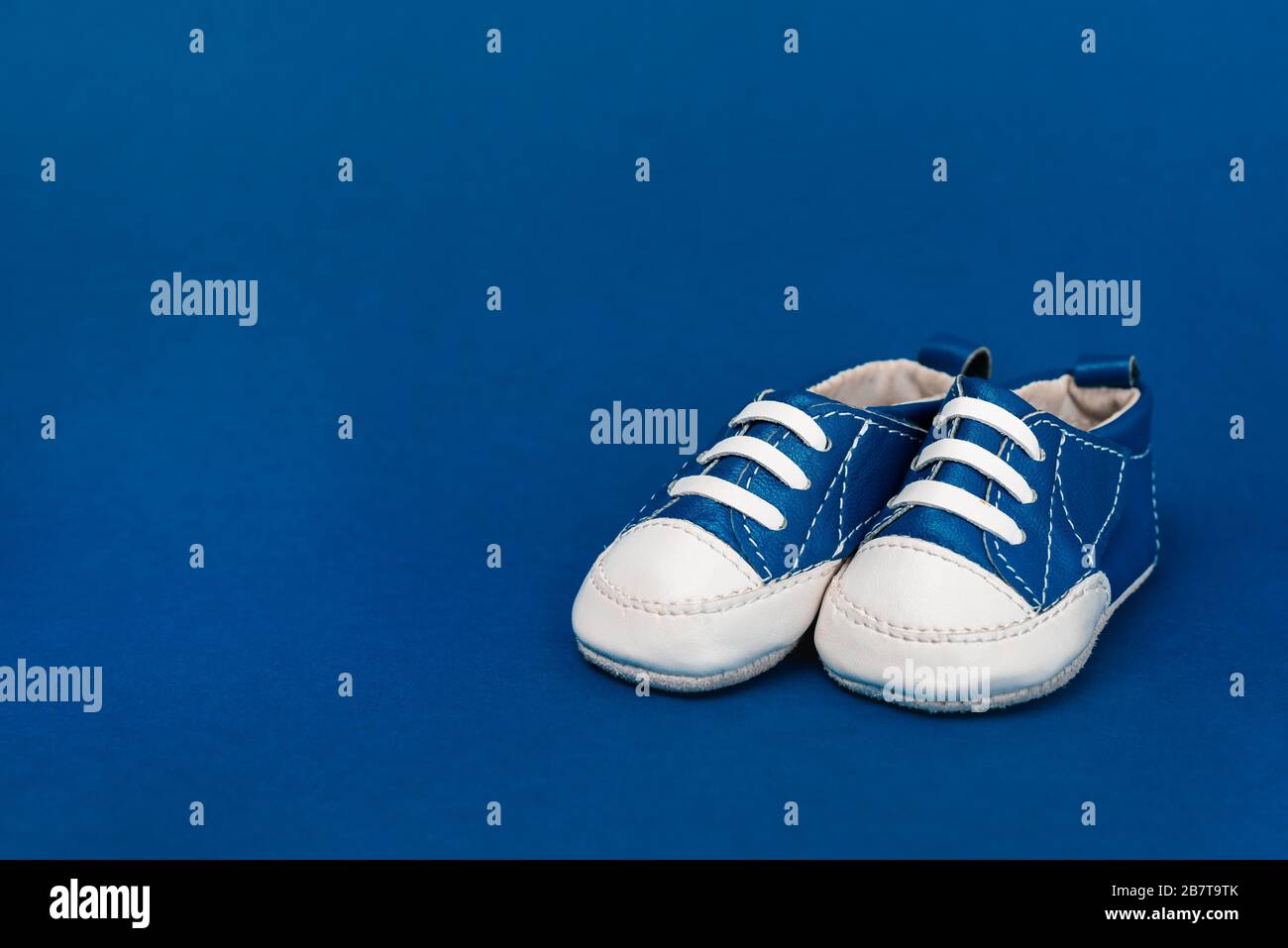 baby shoes on blue background with copy space Stock Photo - Alamy