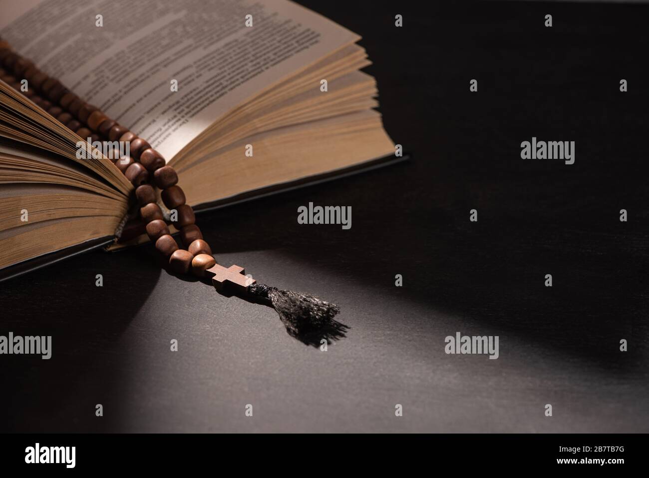 holy bible with rosary on black dark background with sunlight Stock ...