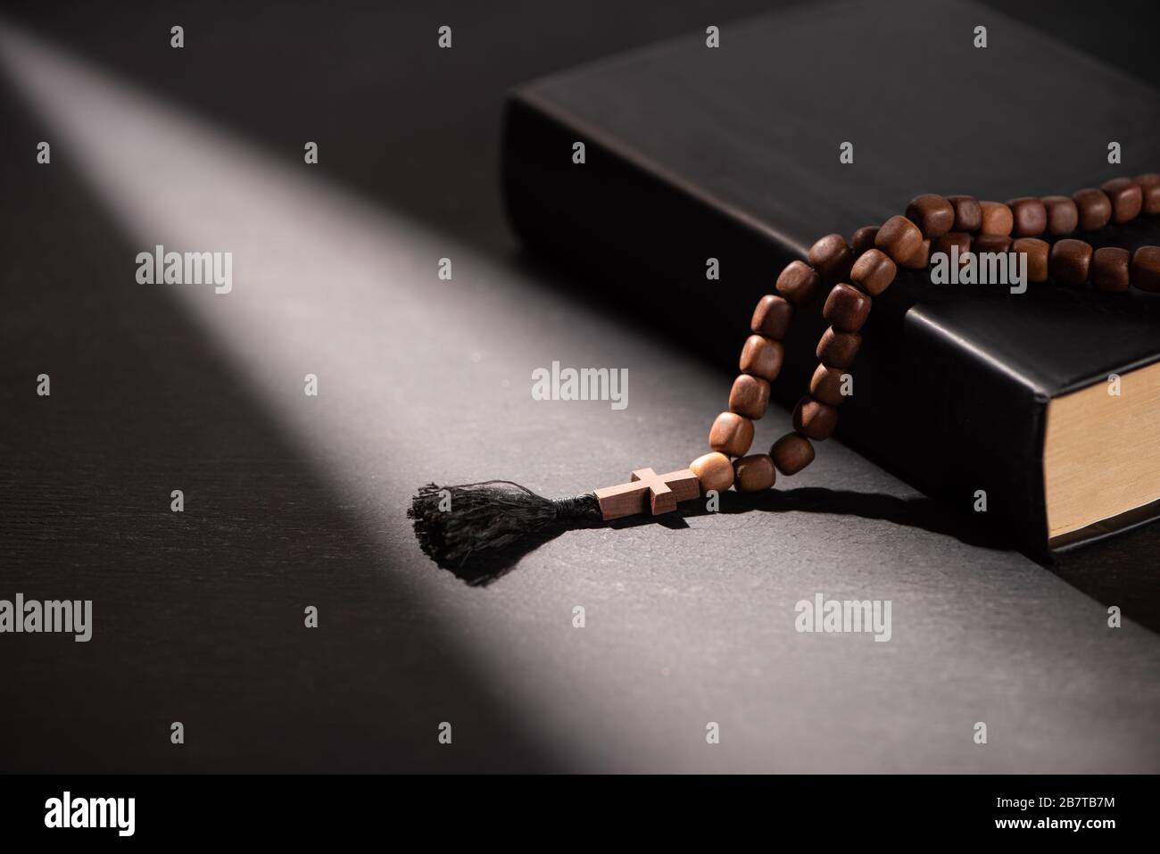 holy bible with rosary on black dark background with sunlight Stock ...