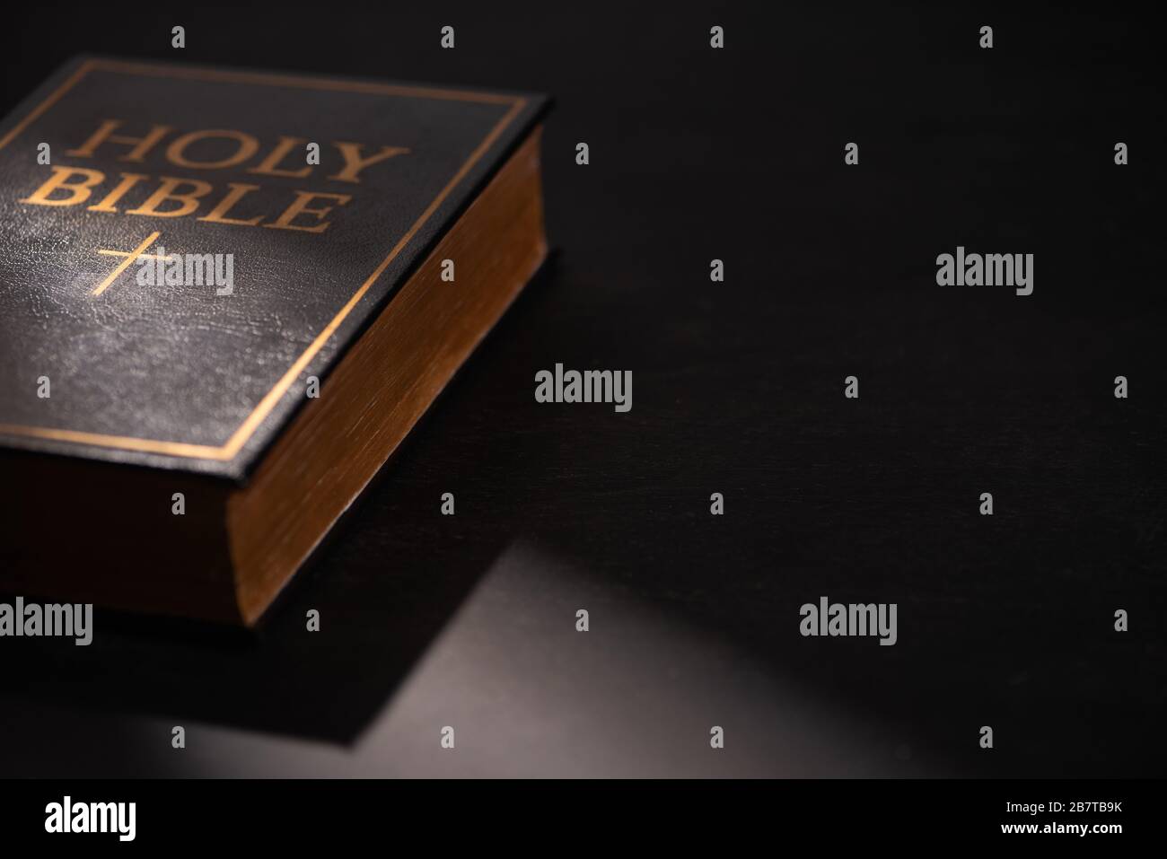 holy bible on black dark background with sunlight Stock Photo - Alamy