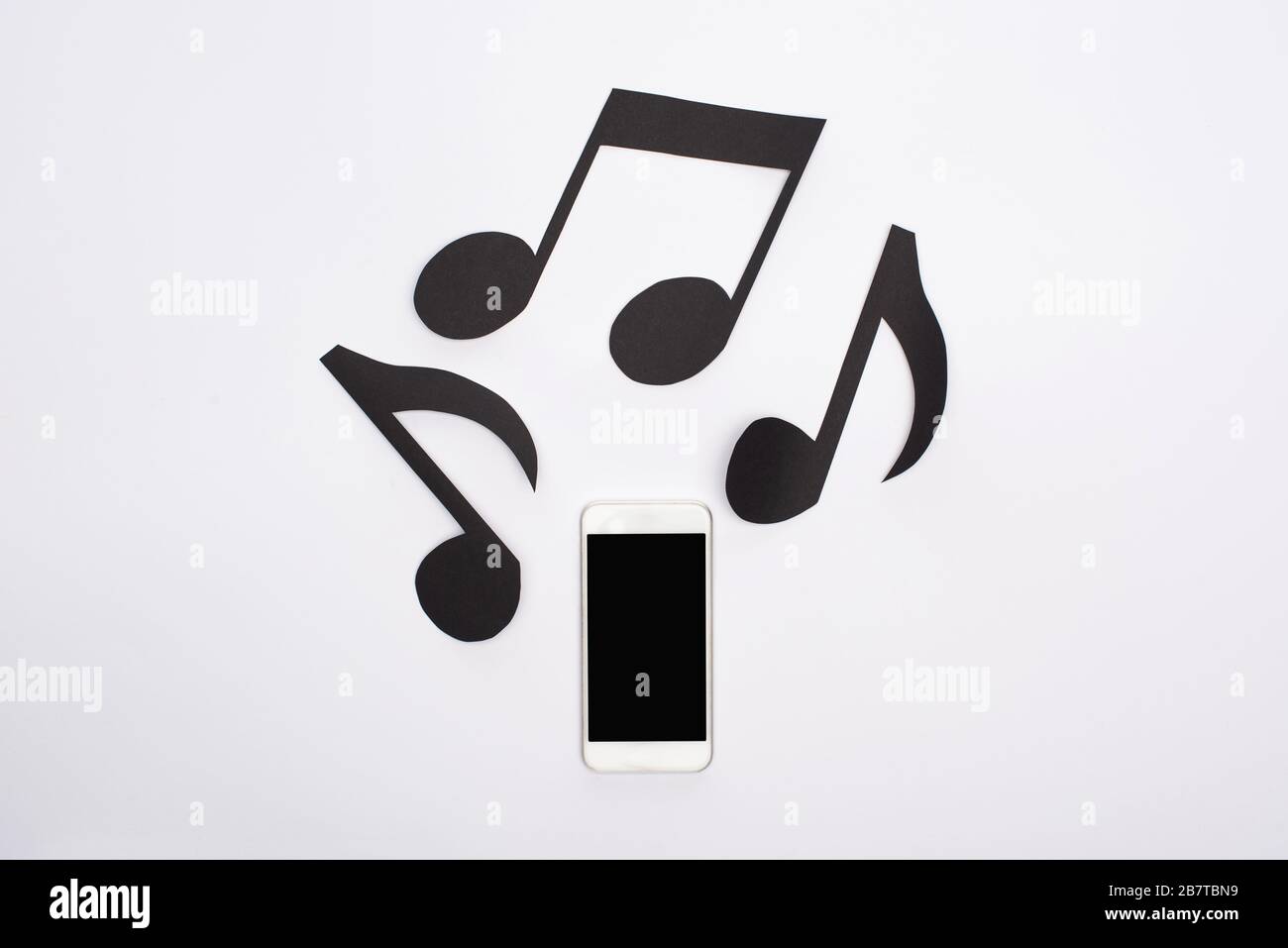 Top view of music paper cut notes and smartphone on white background ...
