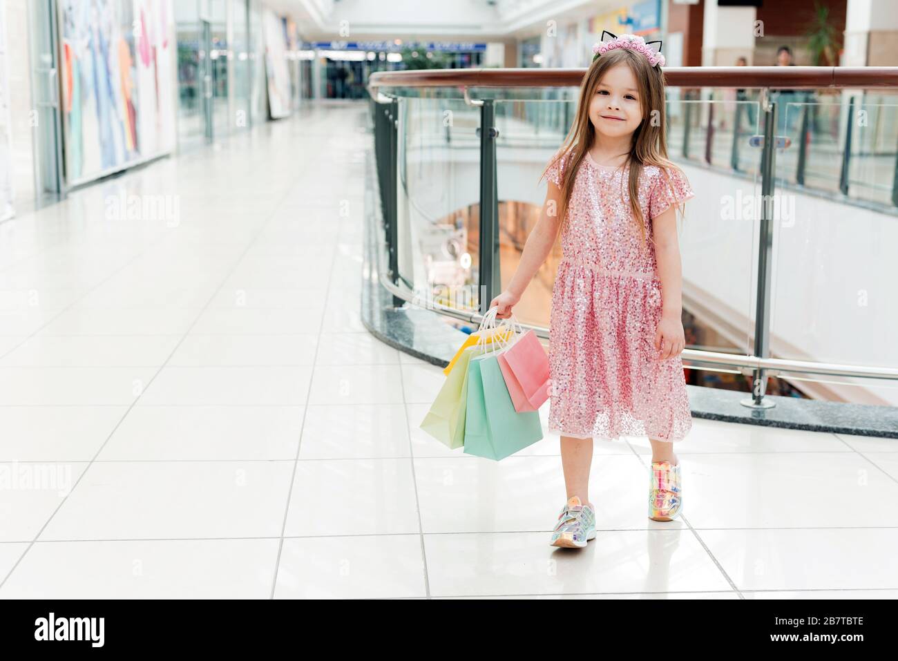 Portrait of a little happy girl in the mall. A smiling laughing girl in ...