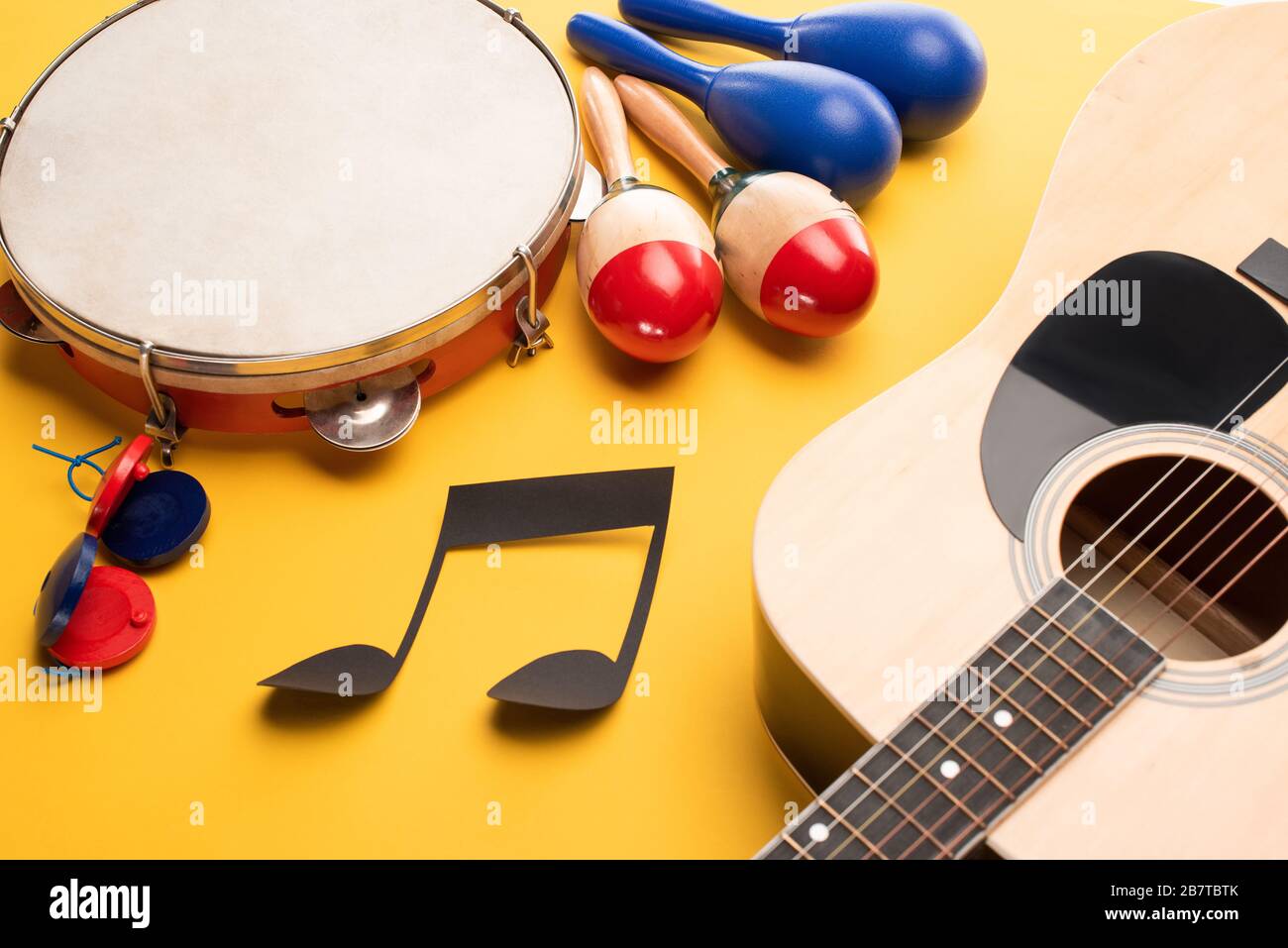 Musical instruments and paper cut music note on yellow background Stock ...