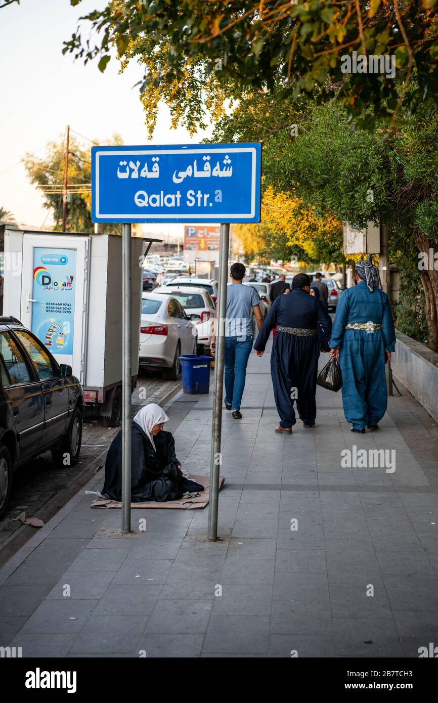 Iraq, Iraqi Kurdistan, Arbil, Erbil. An elderly woman is sitting next ...