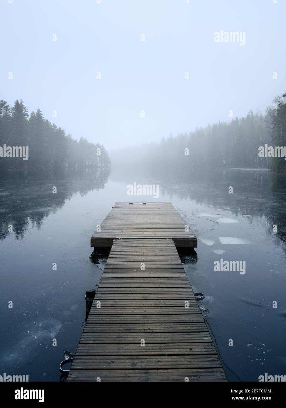 Foggy landscape with calm lake and pier. Mist over water. Foggy air ...