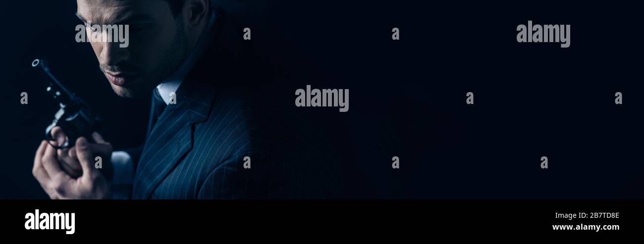 Gangster holding revolver on dark background, panoramic shot Stock ...