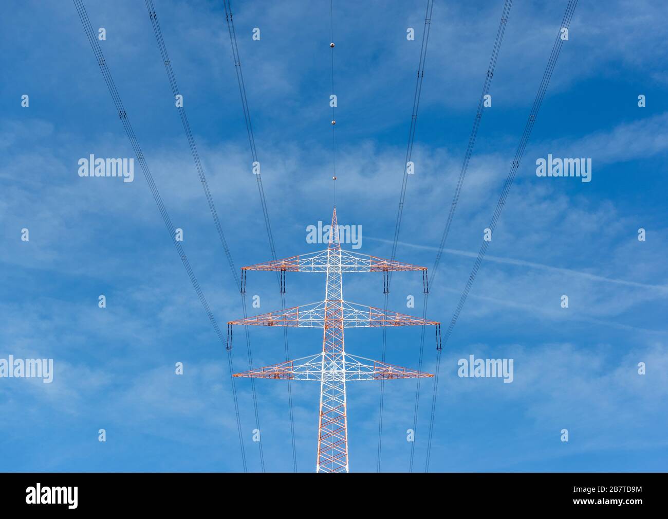 Straight veiw od a red and white electricity pylon with a blue sky ...
