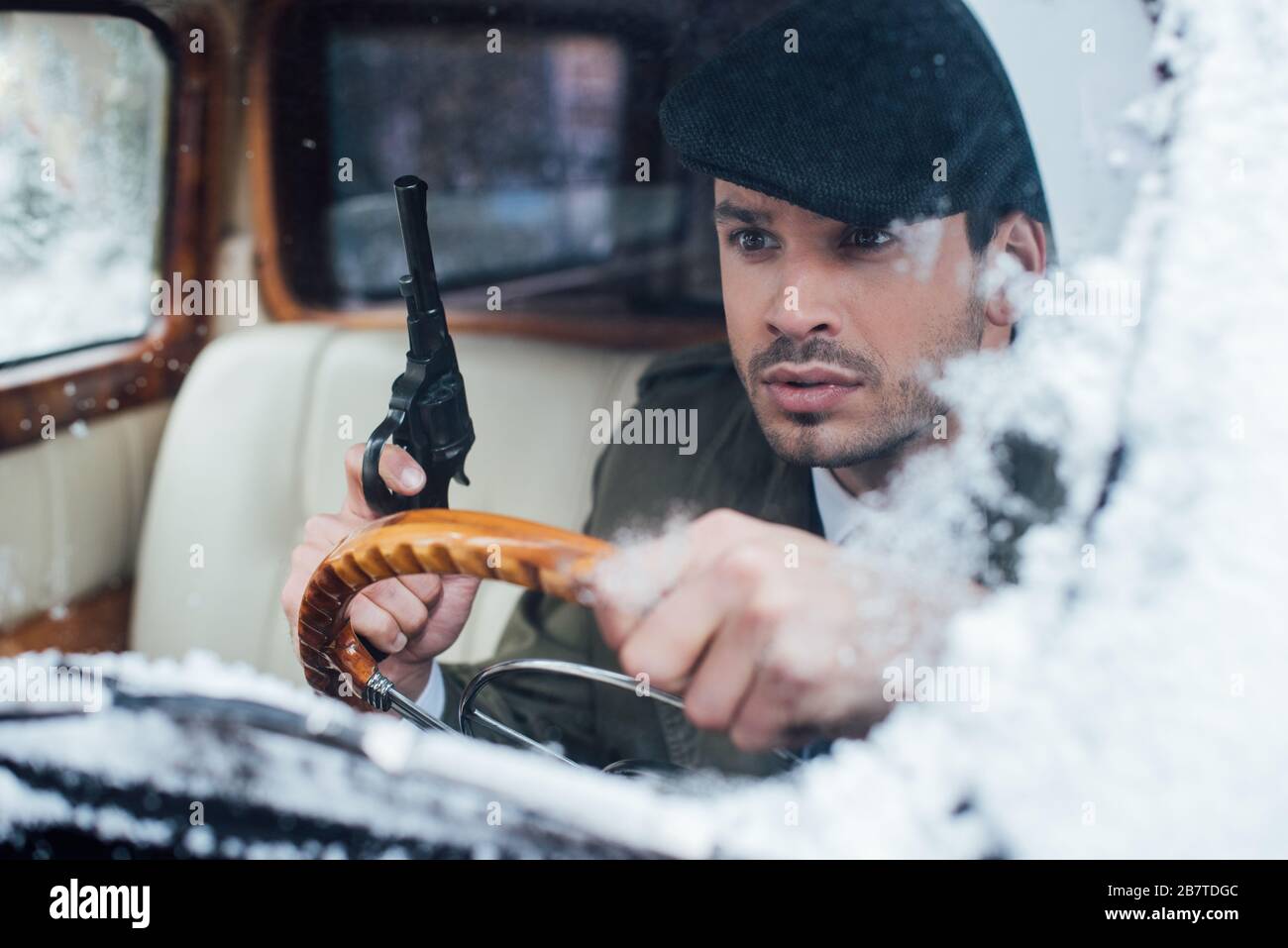 Selective focus of dangerous mafioso with weapon driving car Stock ...